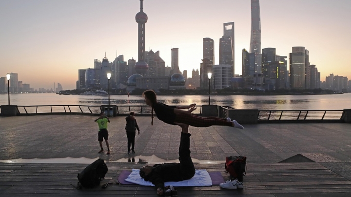 Expats practice yoga at the Bund in Shanghai - China Plus